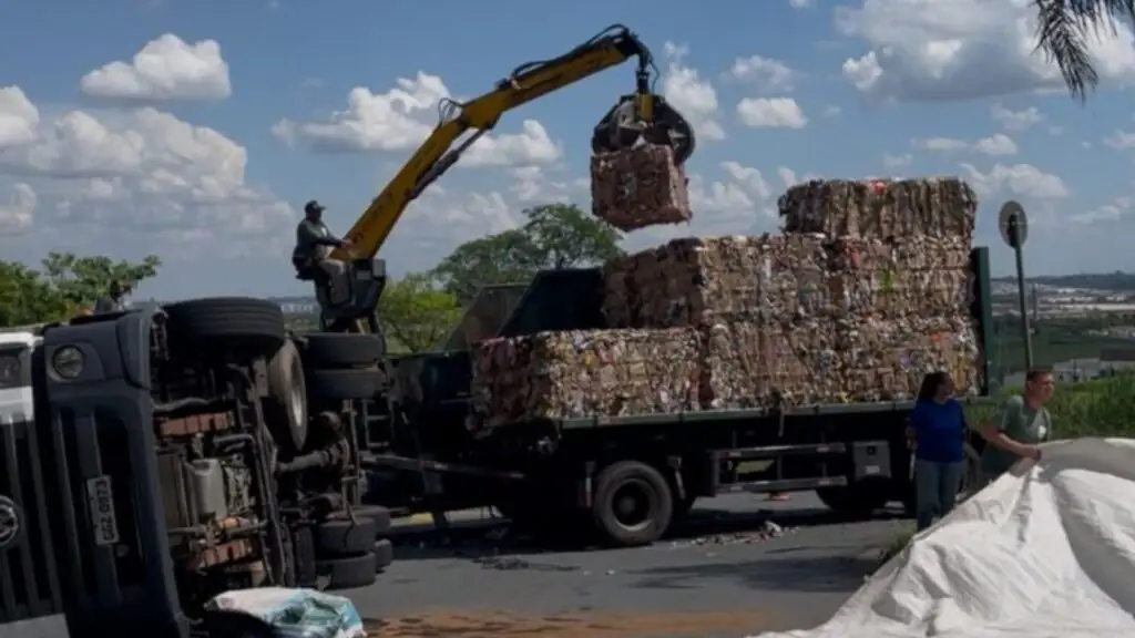 Caminhão carregado com papelão reciclável tomba em rotatória de ...